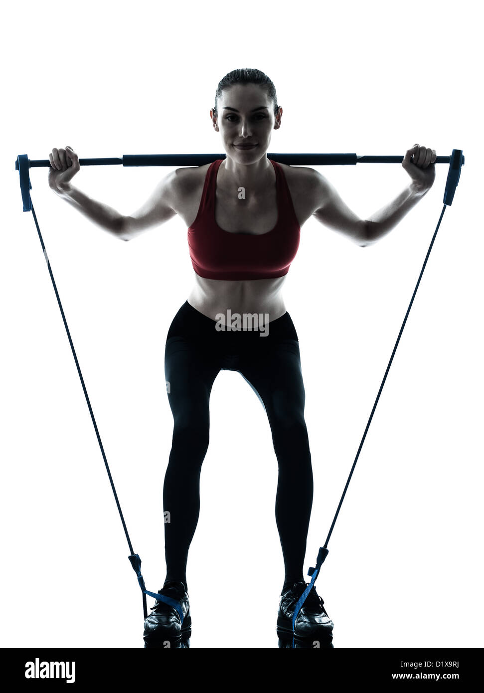 one caucasian woman exercising elastic gymstick in silhouette studio ...