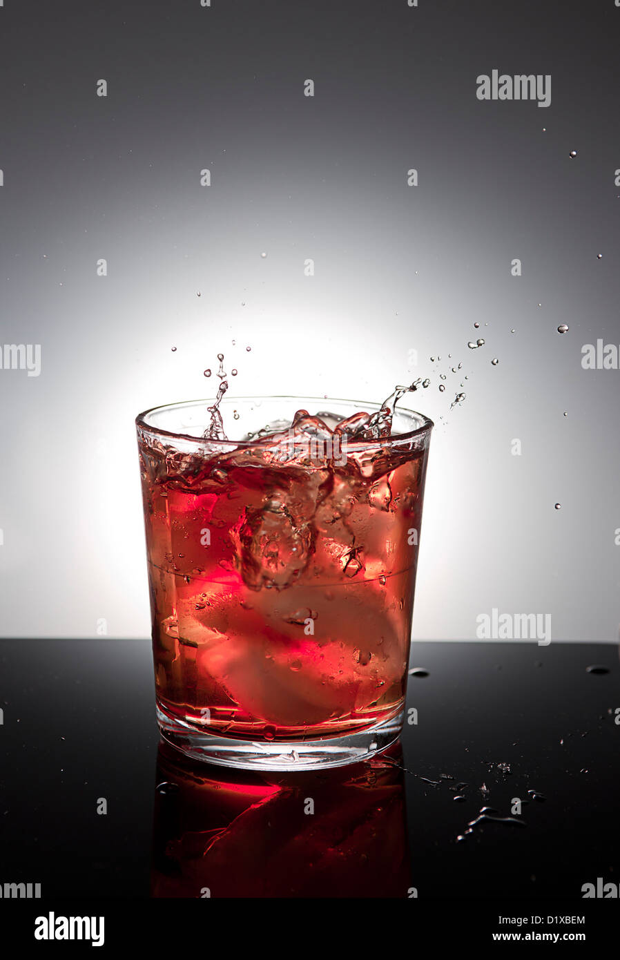 Ice dropping into drink Stock Photo - Alamy