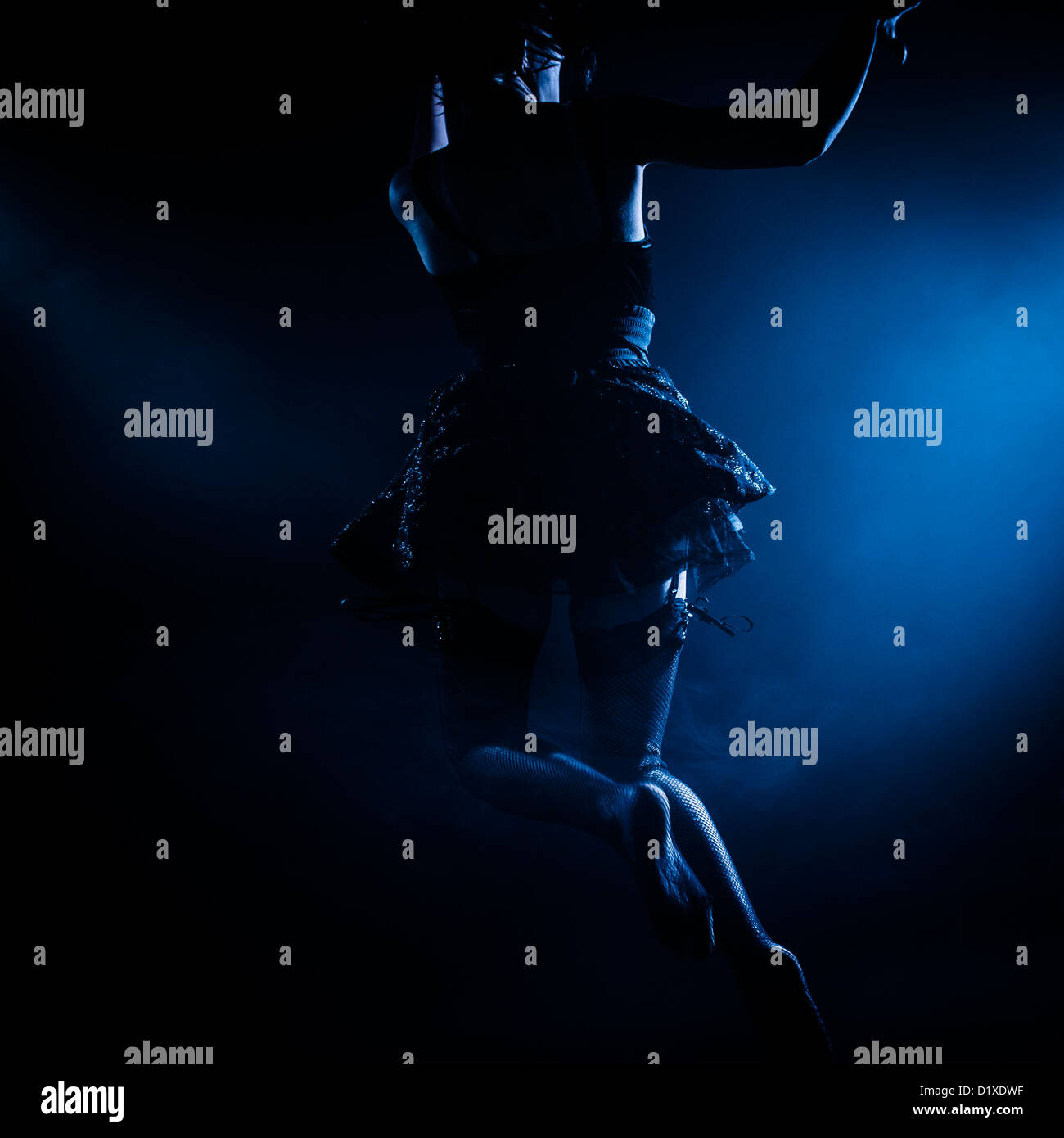 A young woman dancer dancing in blue lit smoke smokey studio Stock ...