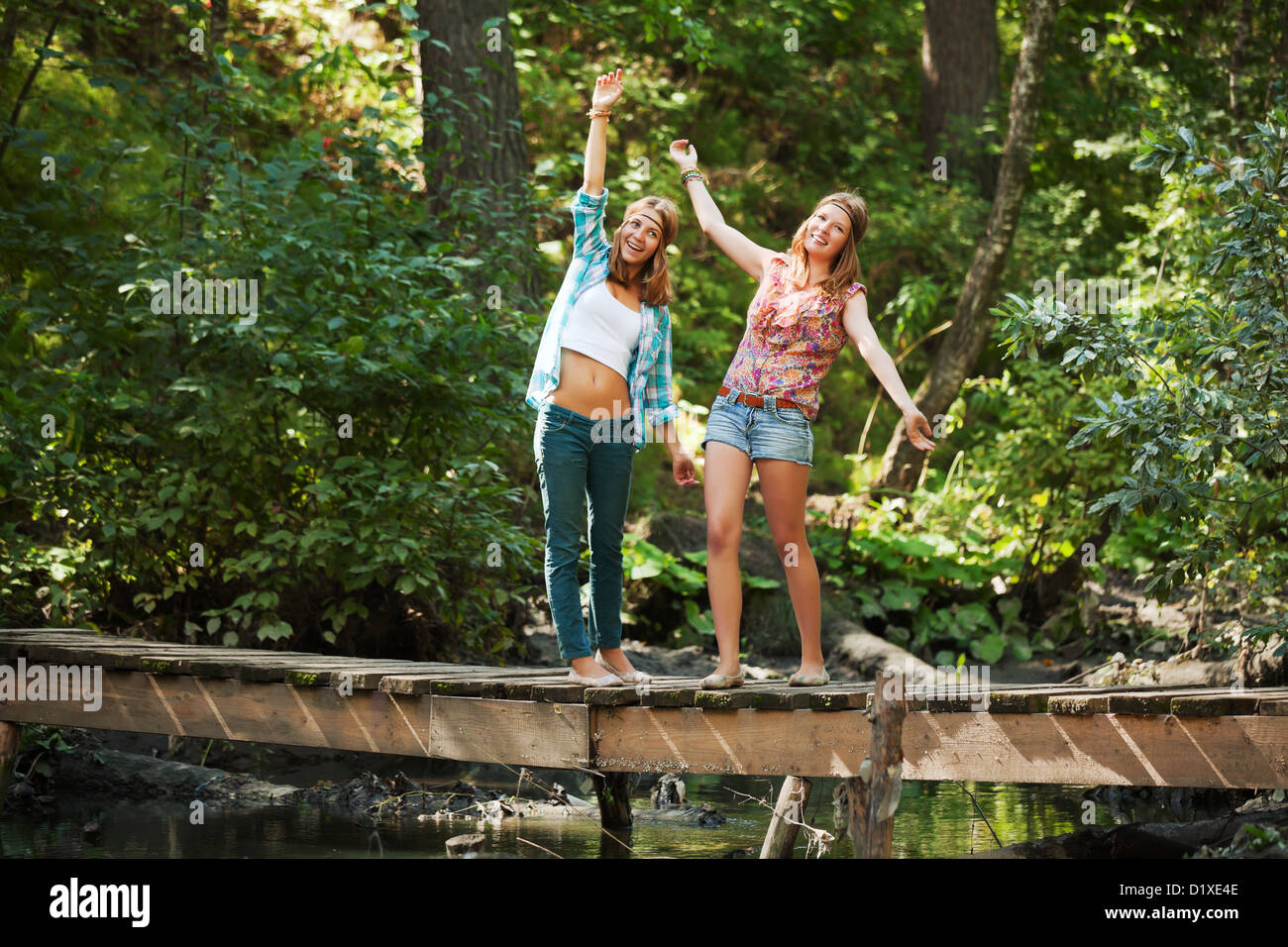 Young girls on the wooden bridge Stock Photo - Alamy