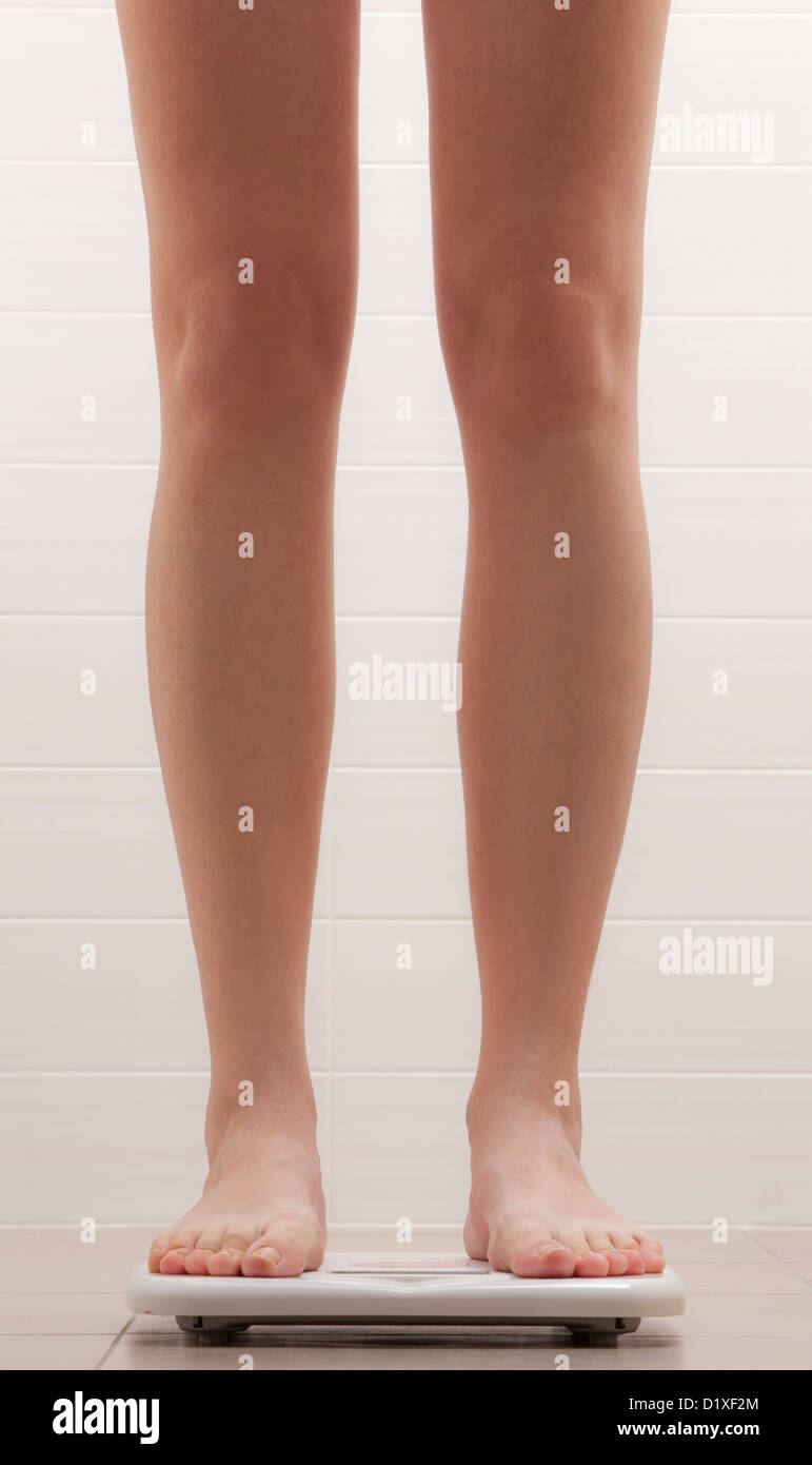 legs of woman standing on a weighing scale Stock Photo - Alamy