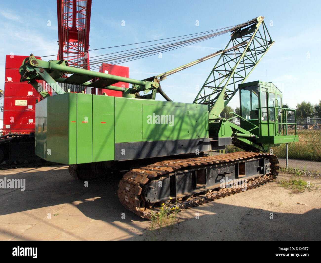 The green tracked crane is a heavy-duty construction machine designed ...