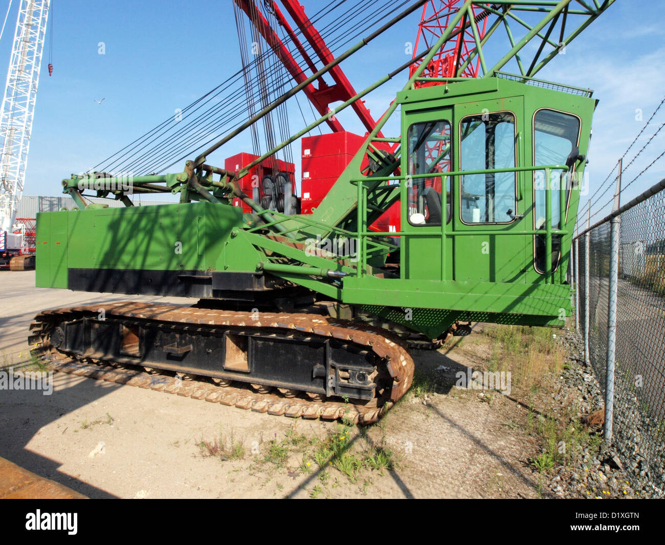 A green tracked crane, an industrial vehicle used for heavy lifting and ...