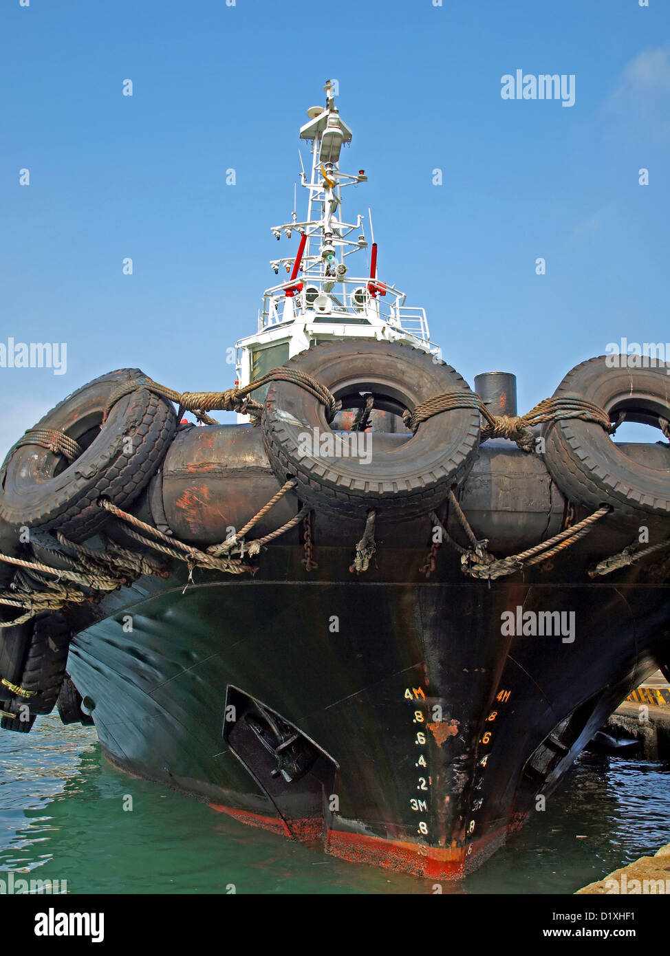 A single tugboat with massive tires fastened to the hull Stock Photo ...