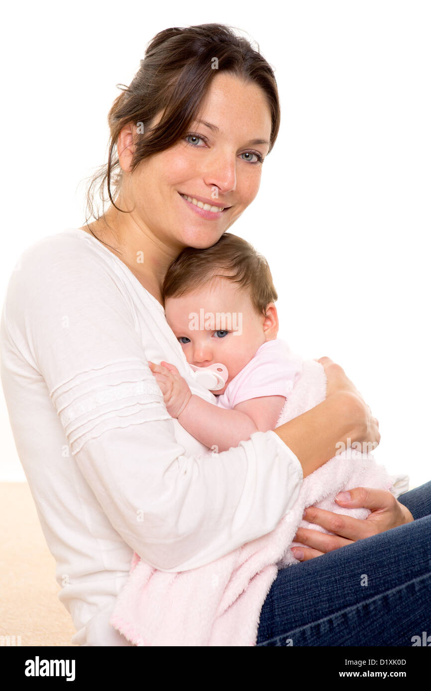 Baby girl relaxed with pacifier hug in mother arms on white background ...
