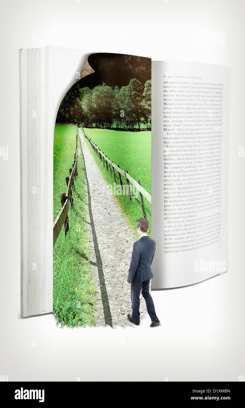 a businessman stepping into a picture in a book Stock Photo - Alamy