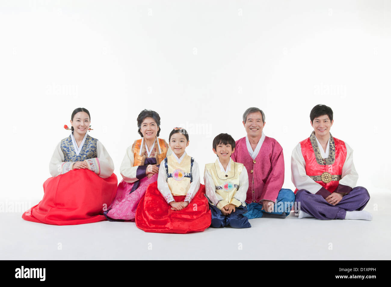 a big family sitting on the floor wearing Hanbok Stock Photo - Alamy