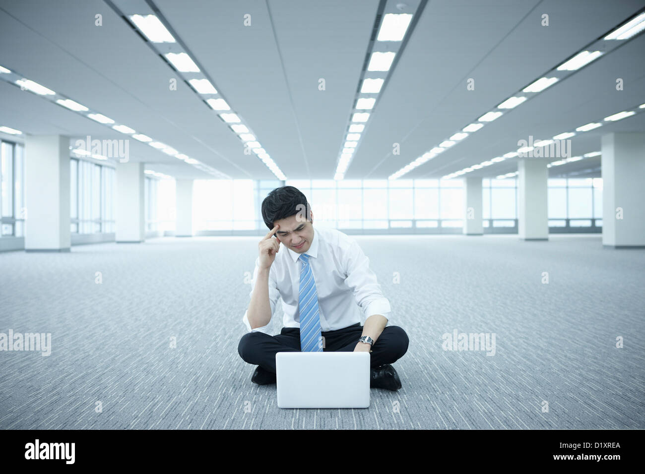 a businessman using laptop on the floor of an empty room Stock Photo ...