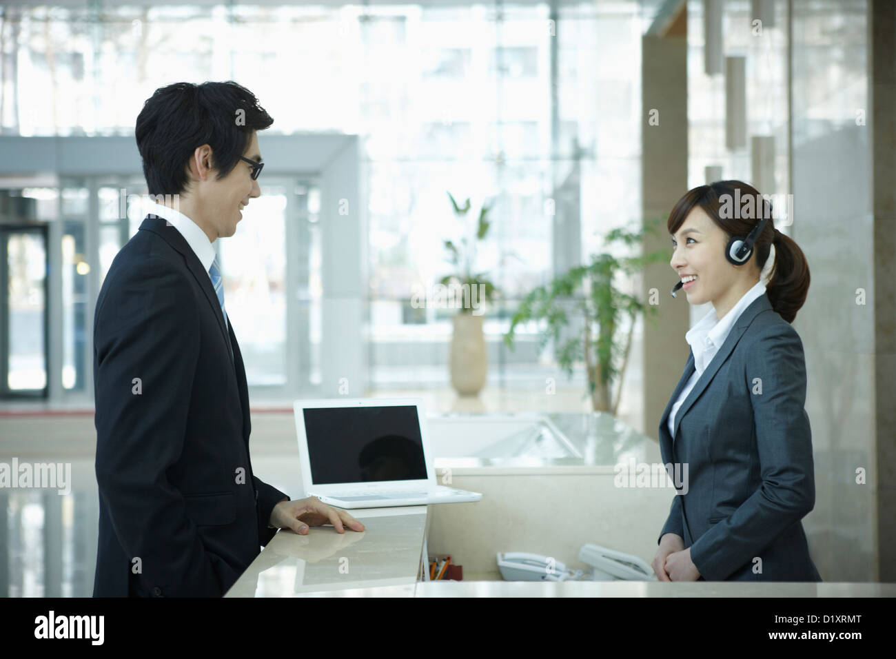 a businessman talking to a help desk in a office building Stock Photo ...