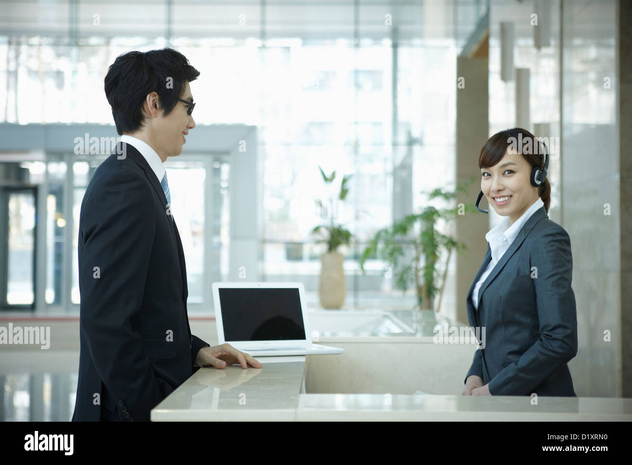 a businessman talking to a help desk in a office building Stock Photo ...