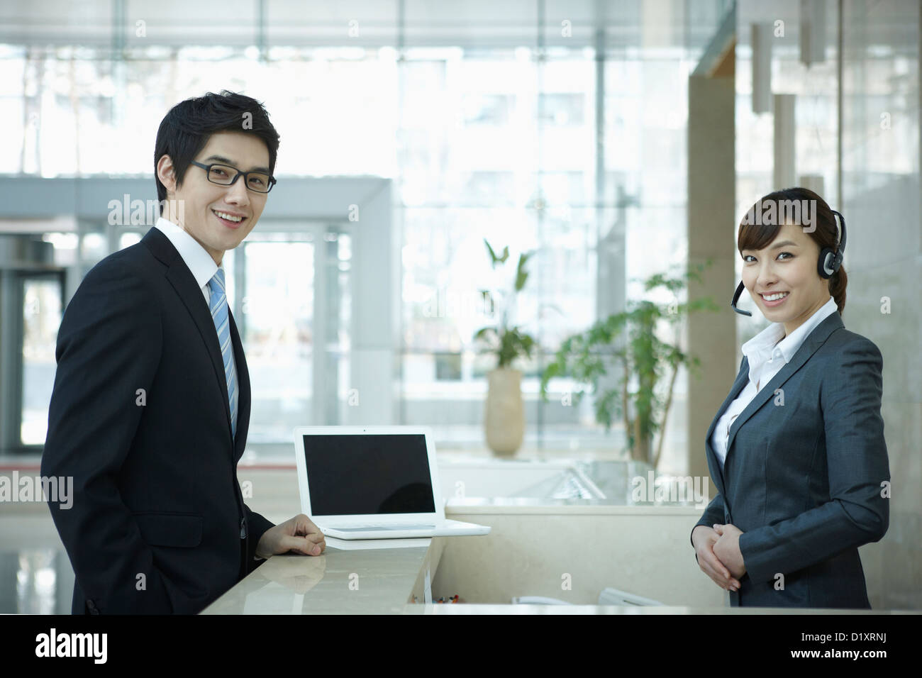 a businessman and help desk woman smiling at camera Stock Photo - Alamy