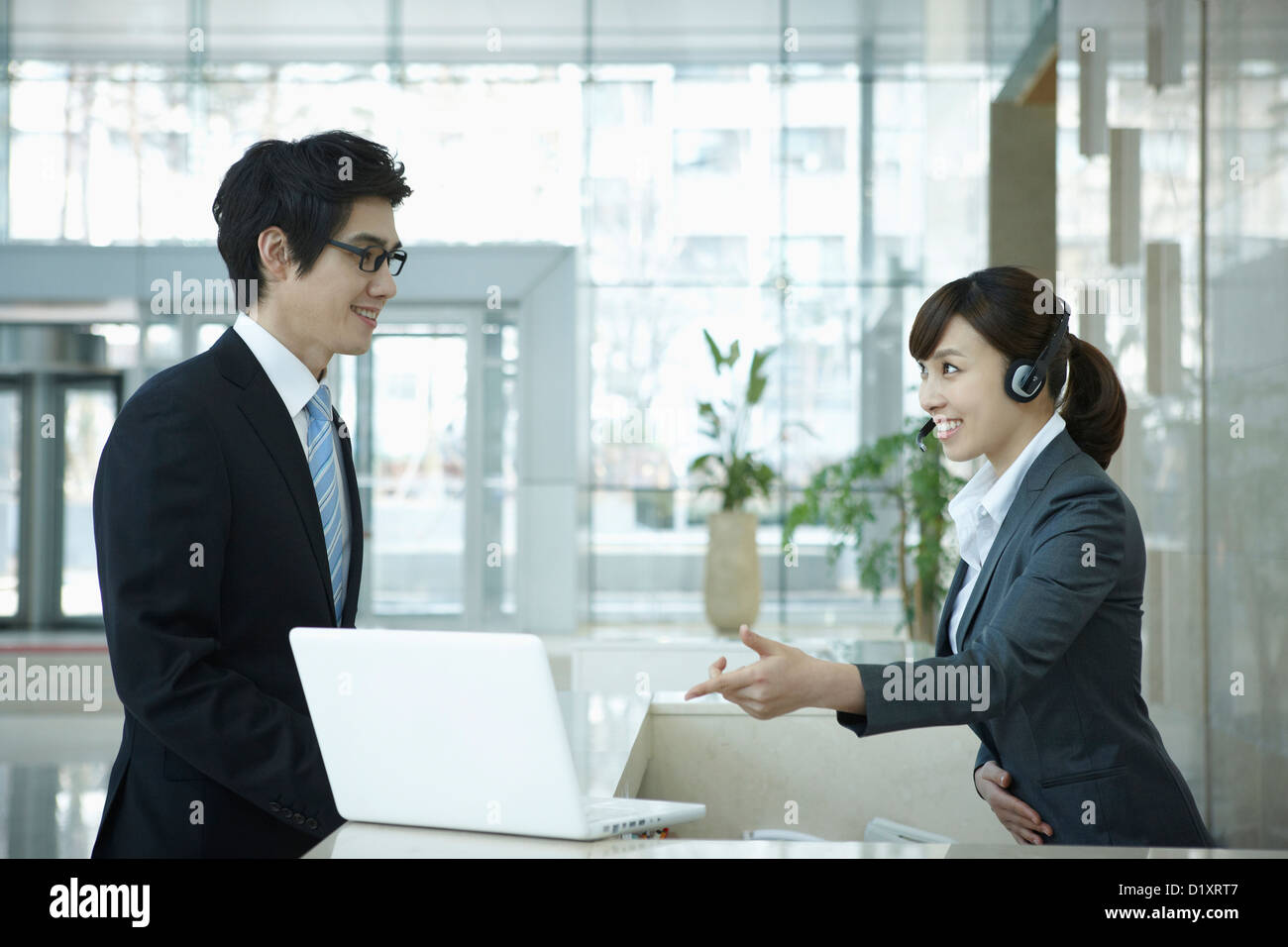 a help desk woman explaining to businessman through laptop Stock Photo ...