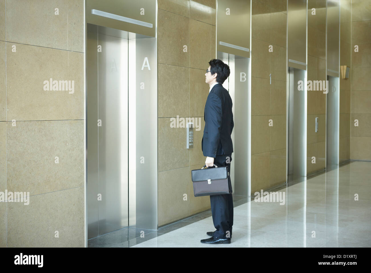 a businessman waiting for an elevator in a office building Stock Photo ...
