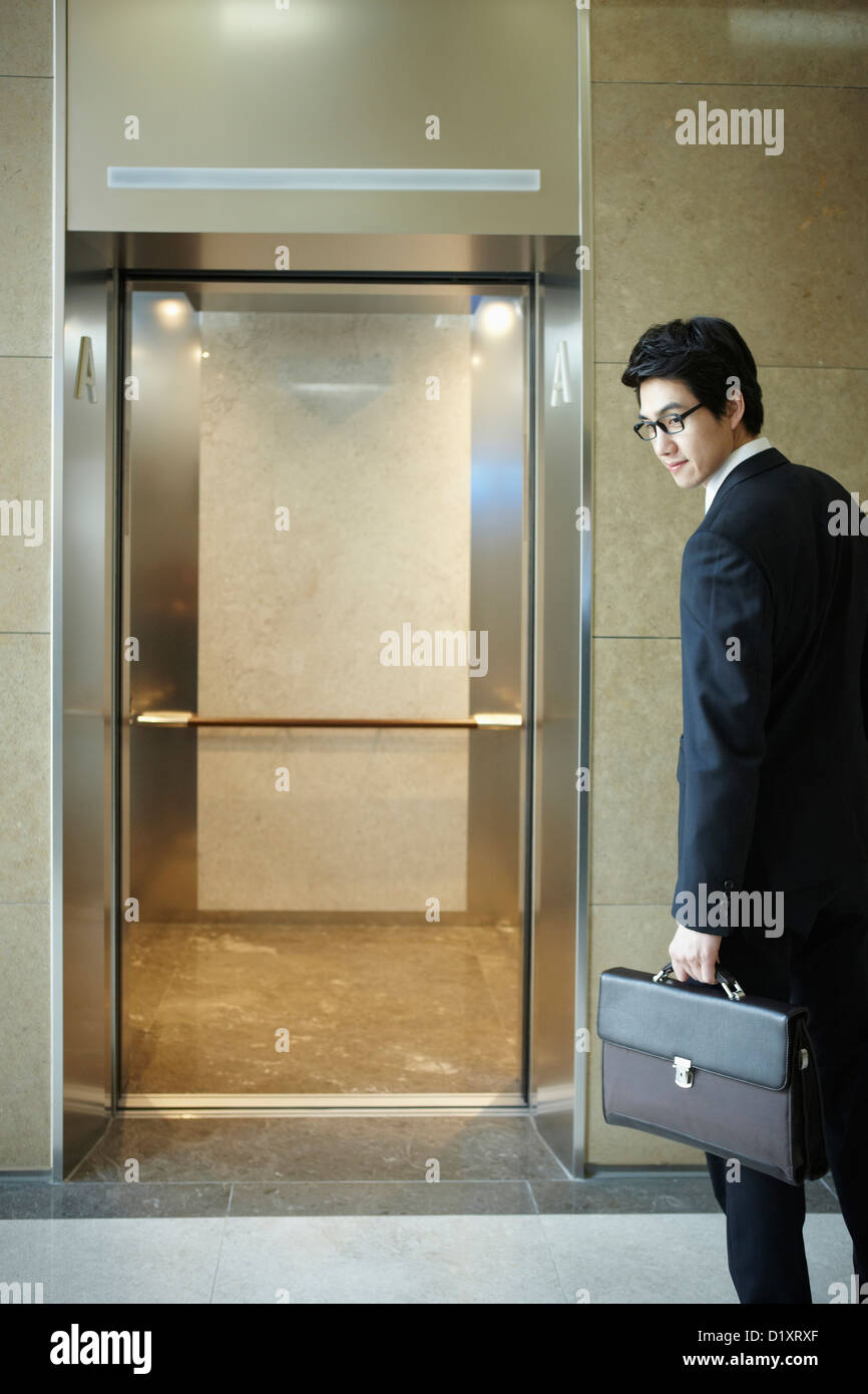 a businessman facing back at camera in front of an empty elevator Stock ...