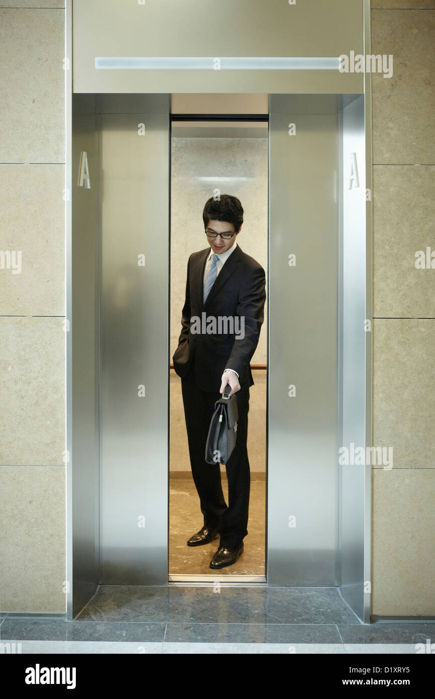 a businessman holding a bag between elevator doors Stock Photo - Alamy