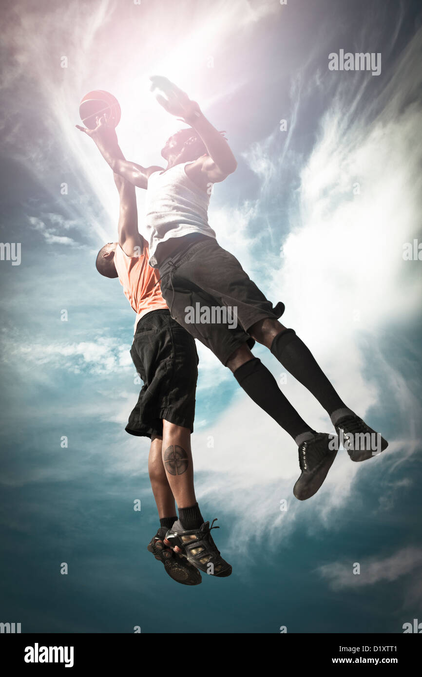 Two Basketball players playing street basket and jumping together to ...
