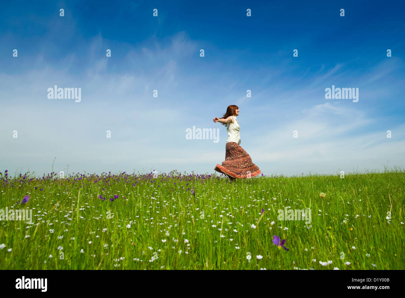 Young woman dancing on a beautiful green meadow Stock Photo - Alamy