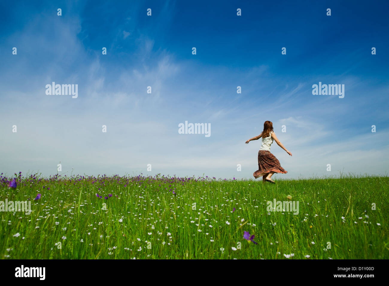 Young woman dancing on a beautiful green meadow Stock Photo - Alamy