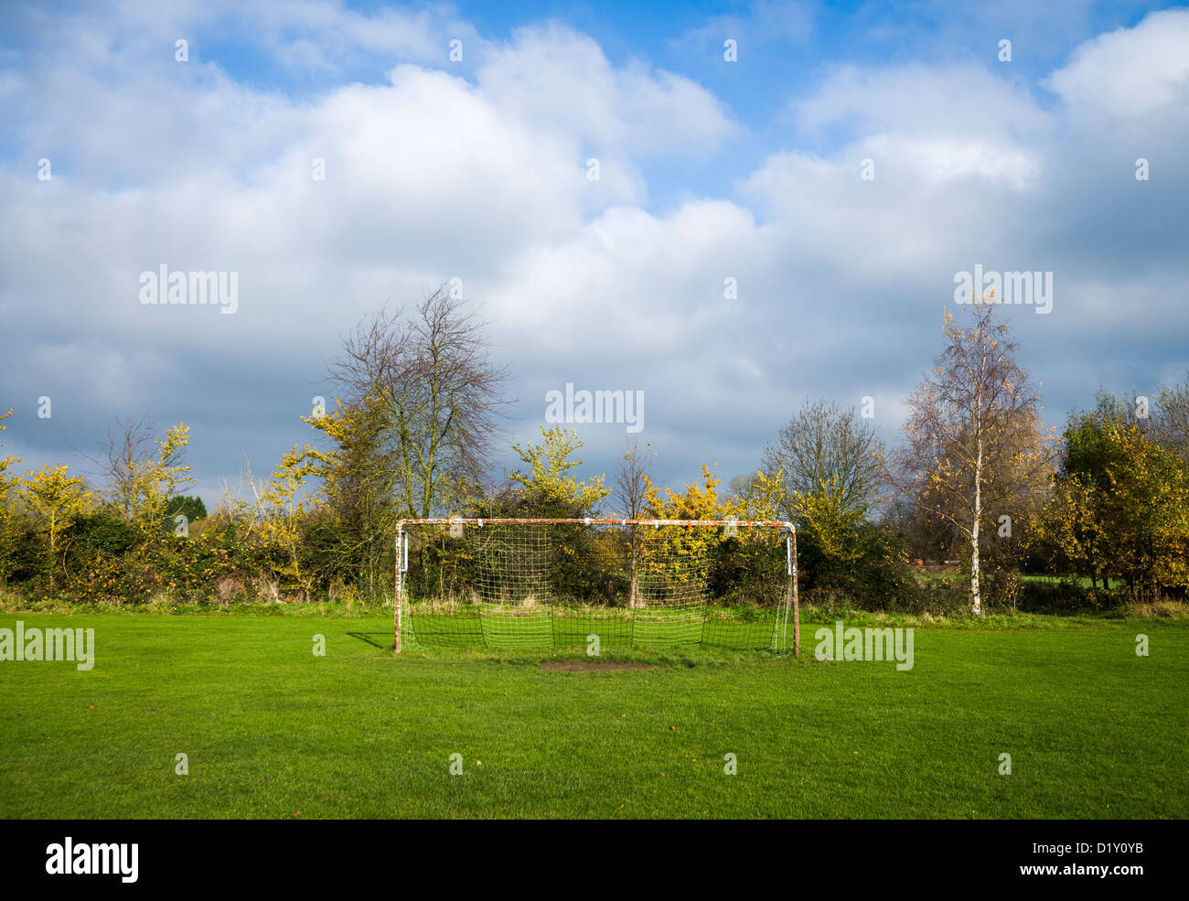 Old rusted football goal in park with green grass and white clouds ...