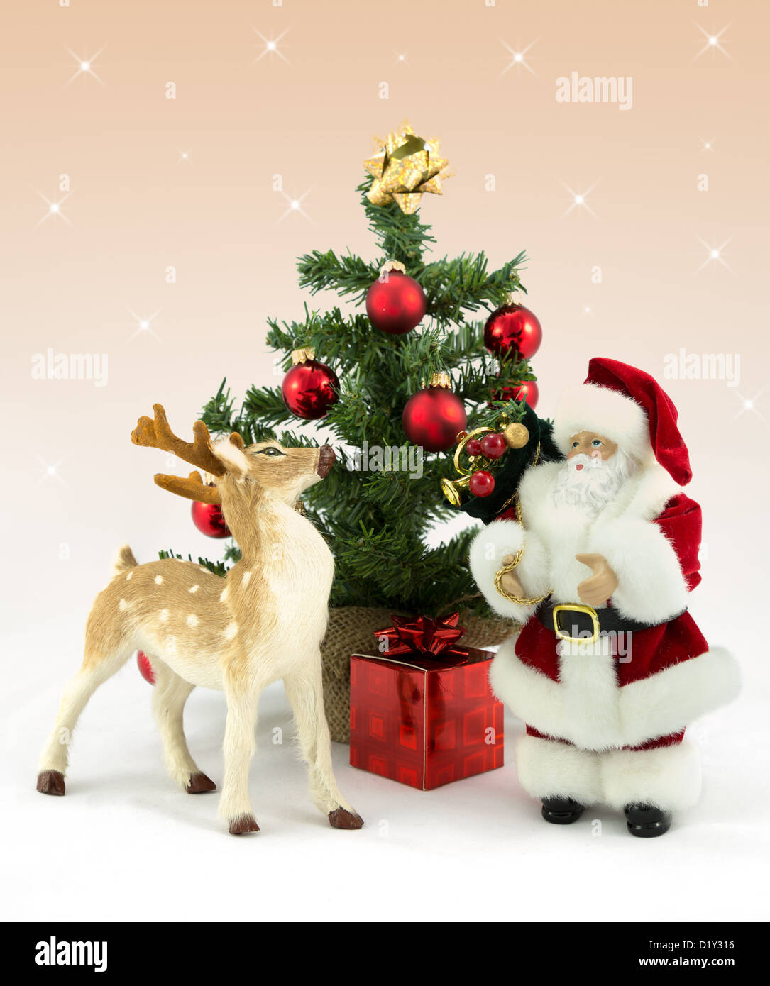 Father christmas with reindeer stood in front of a christmas tree Stock ...
