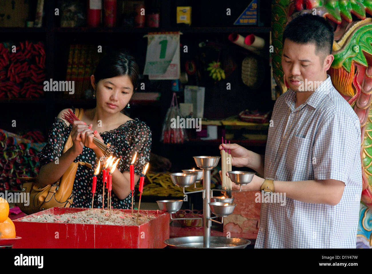 Buddhist devotees light incense as offerings in the Guan Di Chinese ...