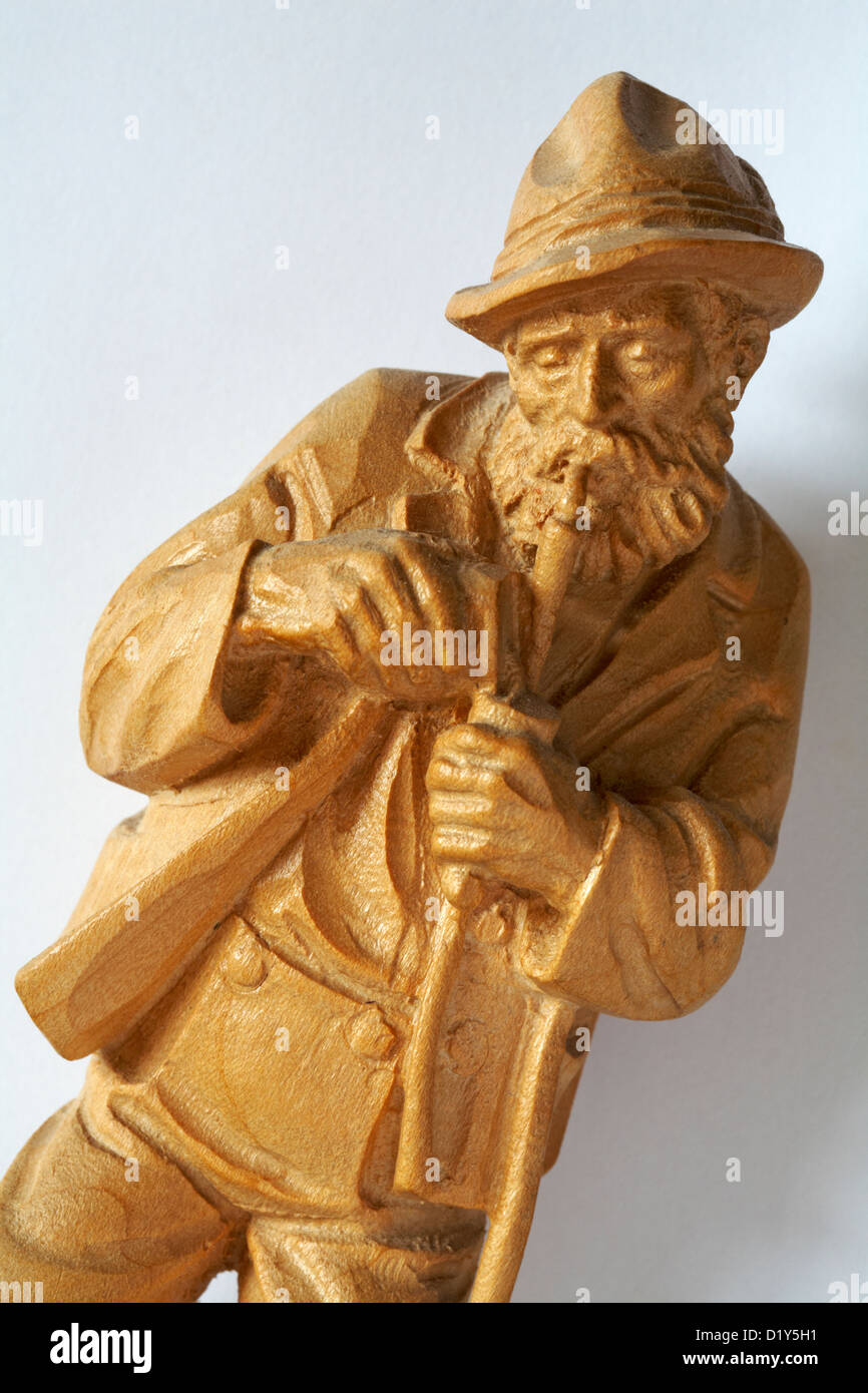Wood carving of old bearded man with pipe set on white background ...