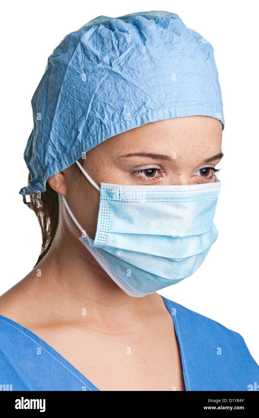 Young female surgeon with scrubs, holding a face mask on a white ...
