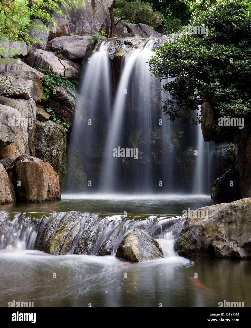 a small waterfall pouring into a pool Stock Photo - Alamy