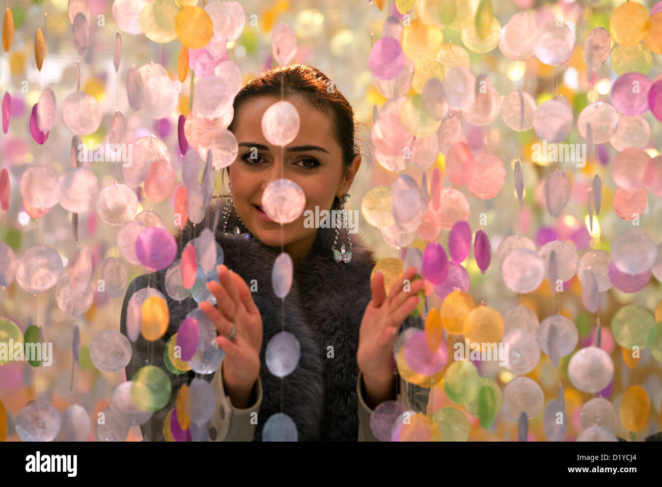 Model Beba looks through a curtain of colorful plastic disks at the ...