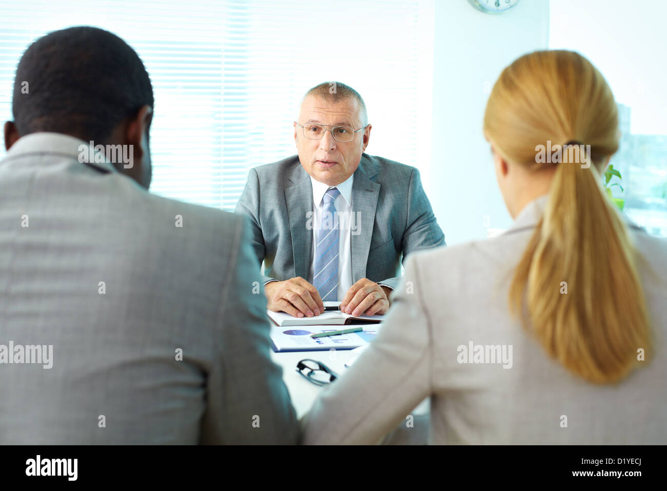 Portrait of serious boss interacting with his employees Stock Photo - Alamy