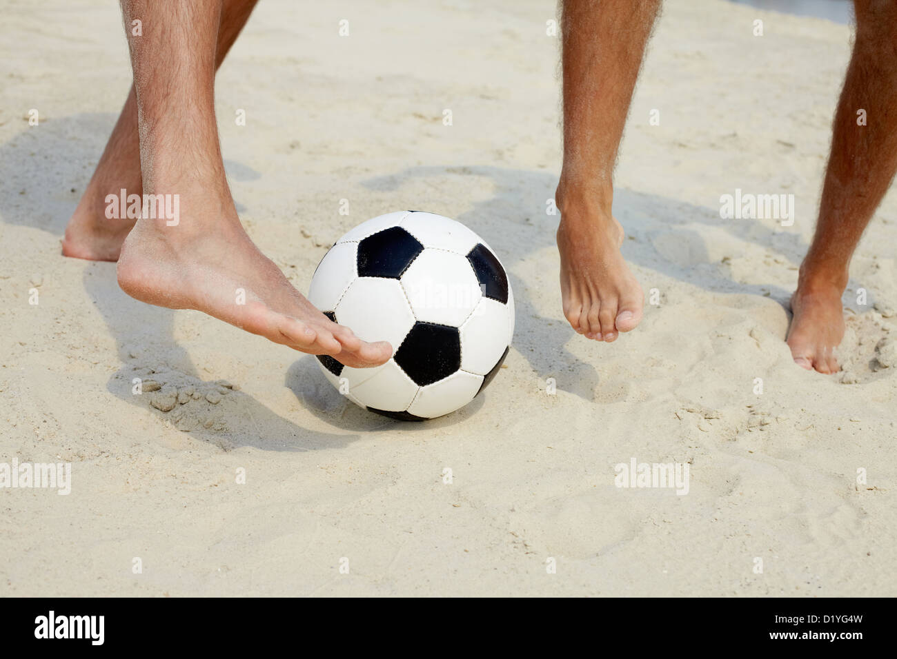 Close-up of male foot playing football on sand Stock Photo - Alamy