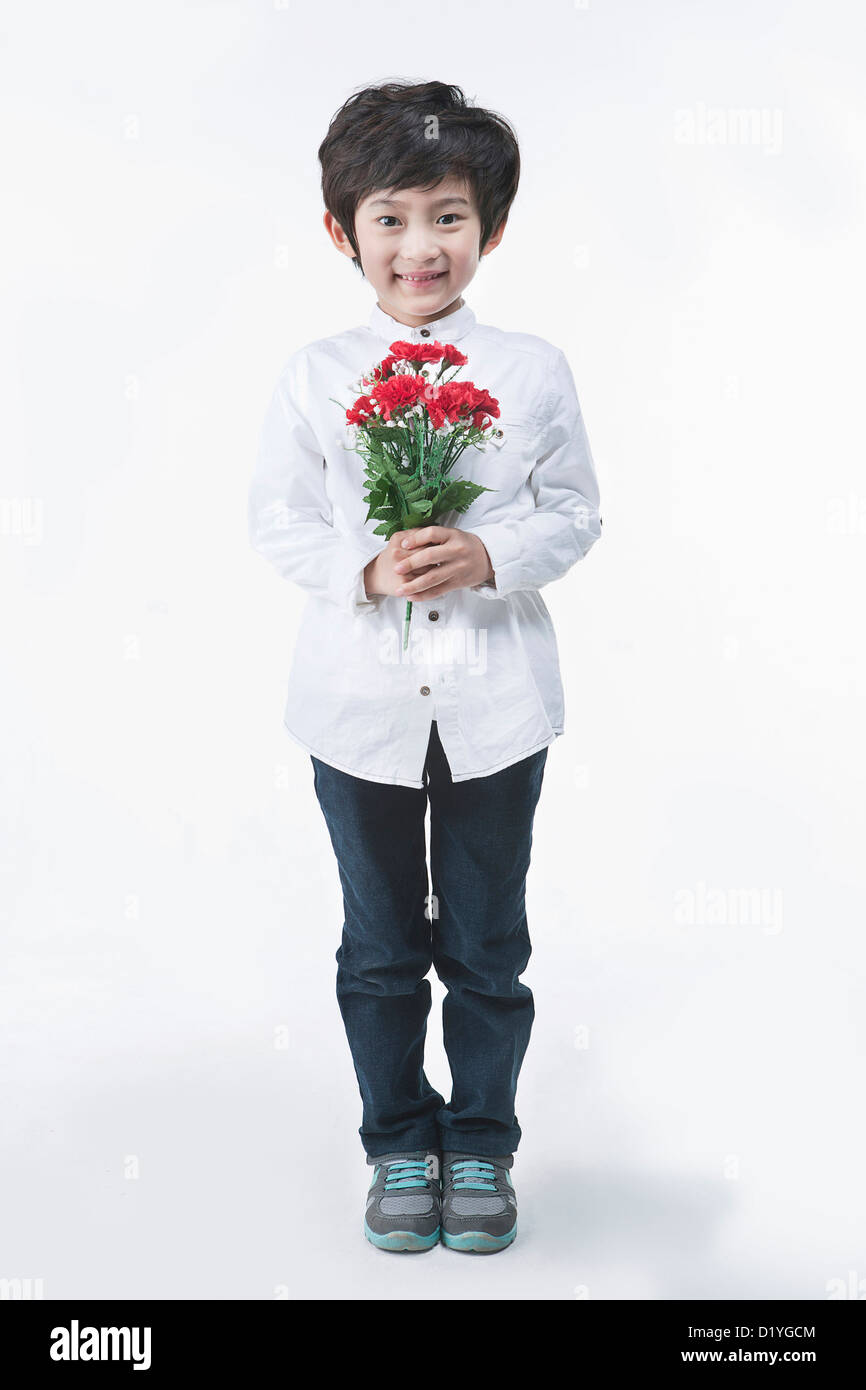 a young boy holding a red flower Stock Photo - Alamy