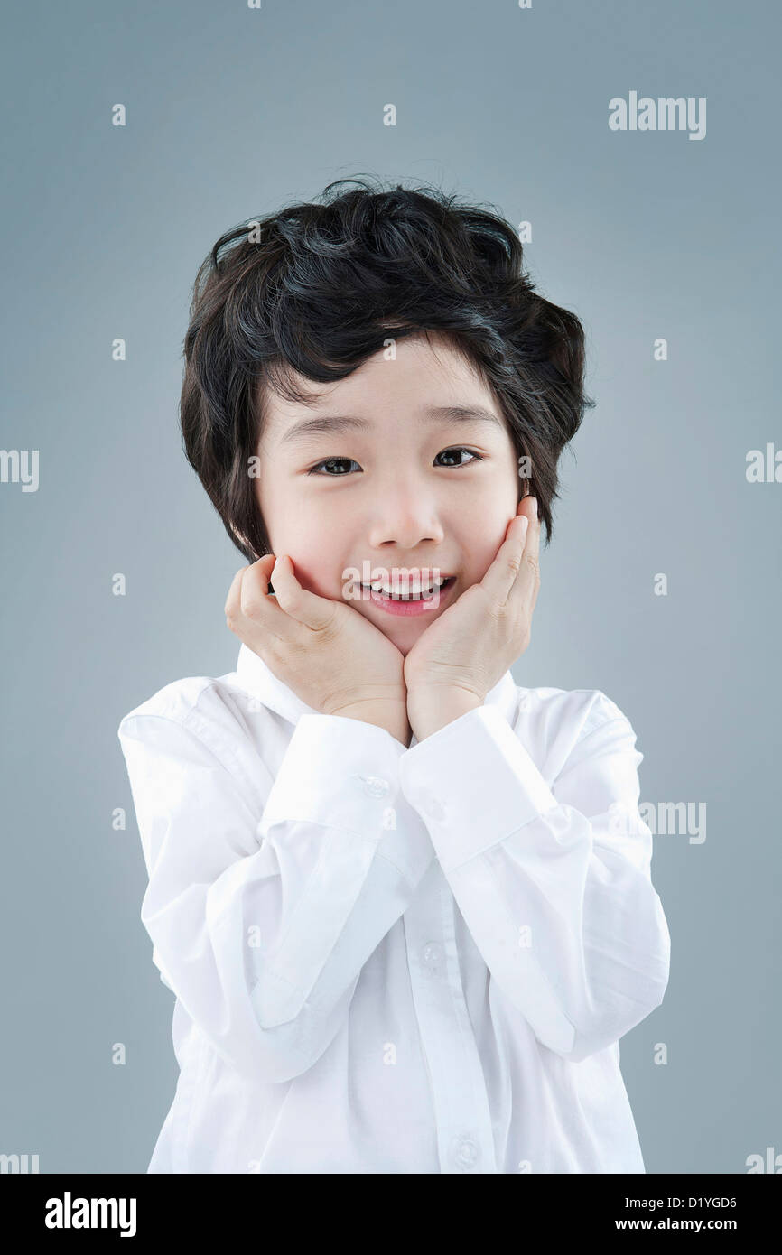 a boy posing with his hands on chin Stock Photo - Alamy
