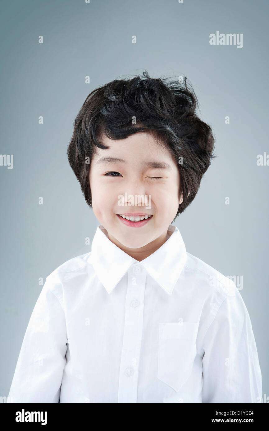 a boy in white shirt winking Stock Photo - Alamy