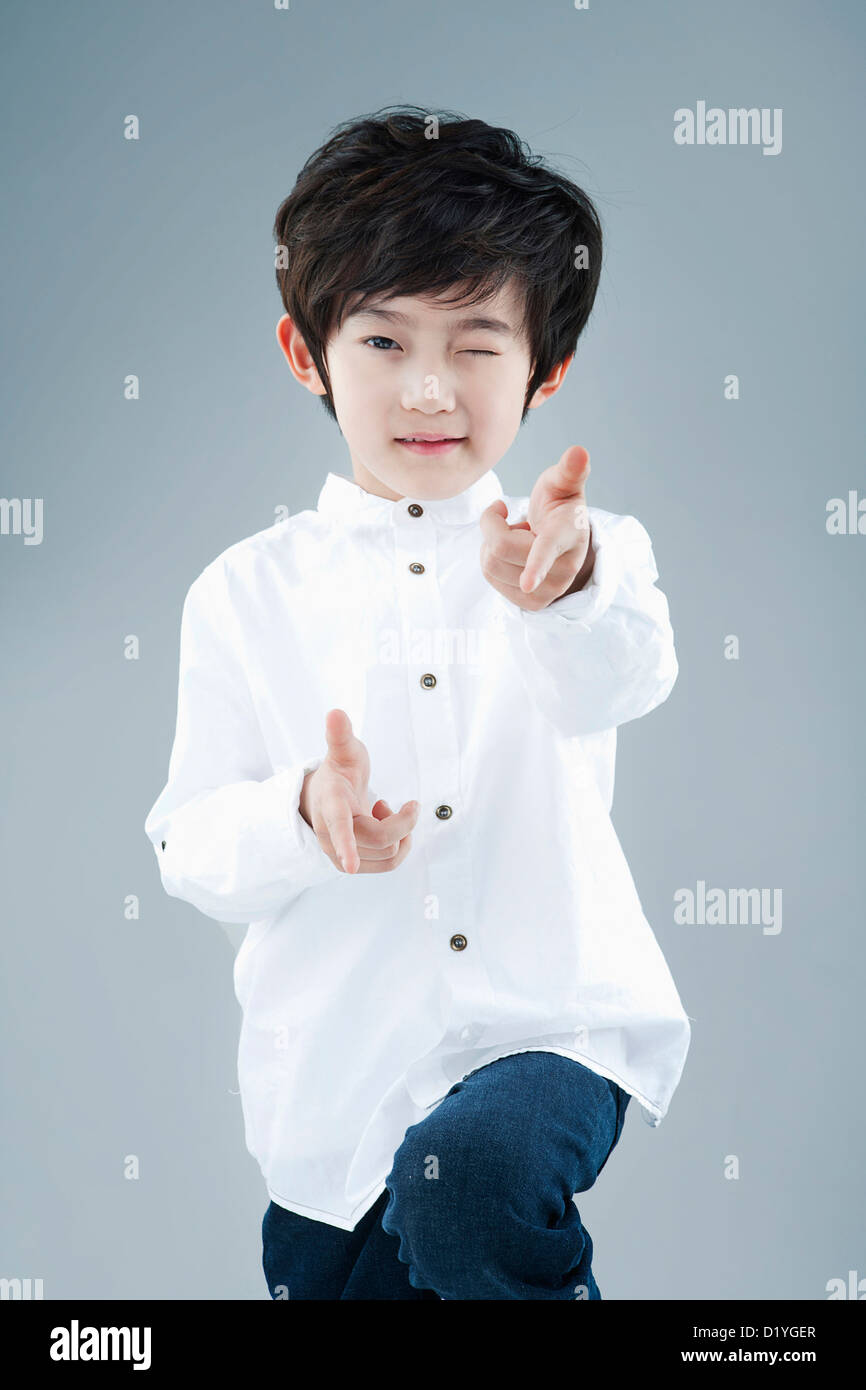 a boy in white shirt posing while winking Stock Photo - Alamy