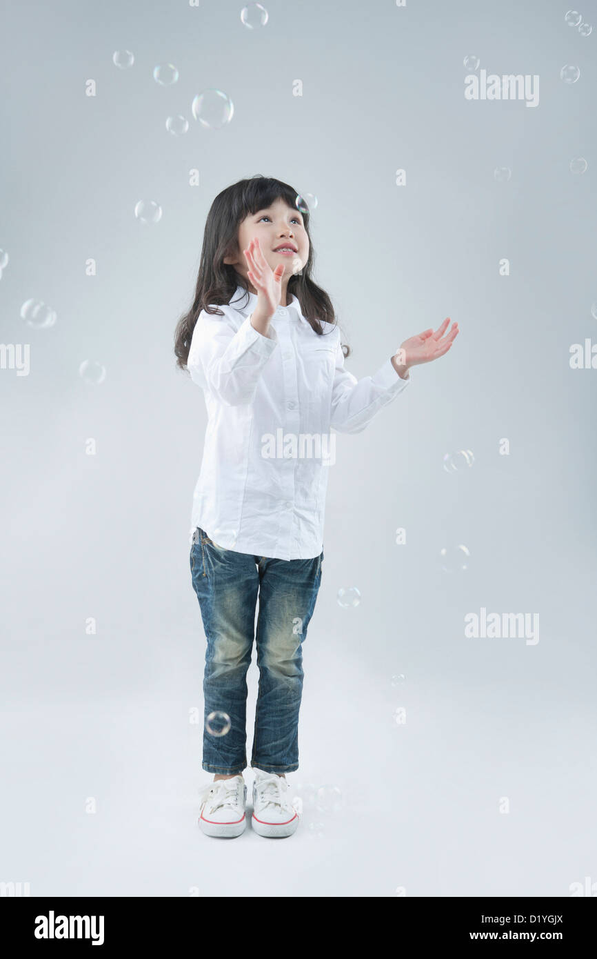a female kid trying to catch bubbles Stock Photo - Alamy