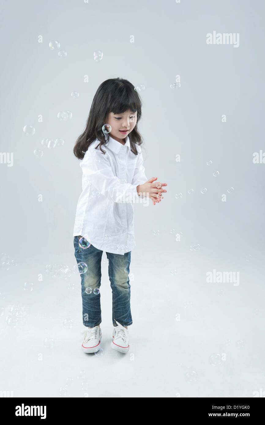 a female kid trying to catch bubbles Stock Photo - Alamy