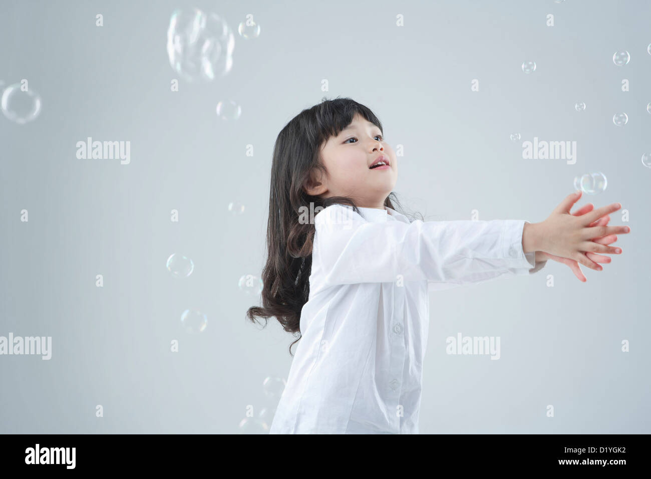 a female kid catching bubbles Stock Photo - Alamy