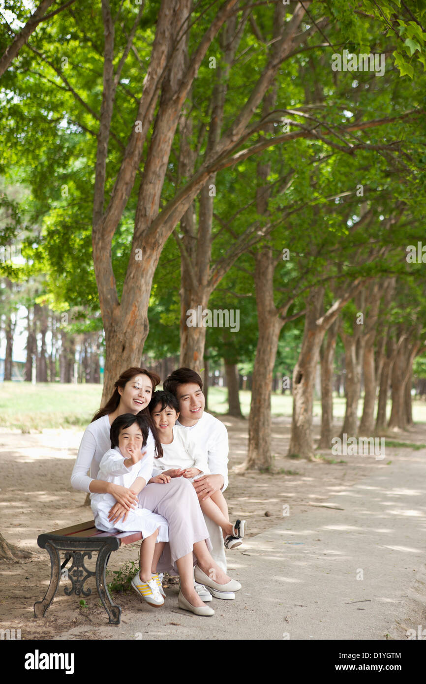 a family sitting on a bench Stock Photo - Alamy