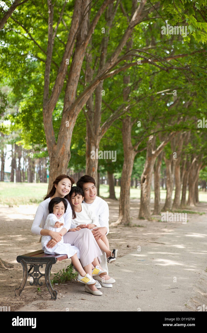a family sitting on a bench Stock Photo - Alamy