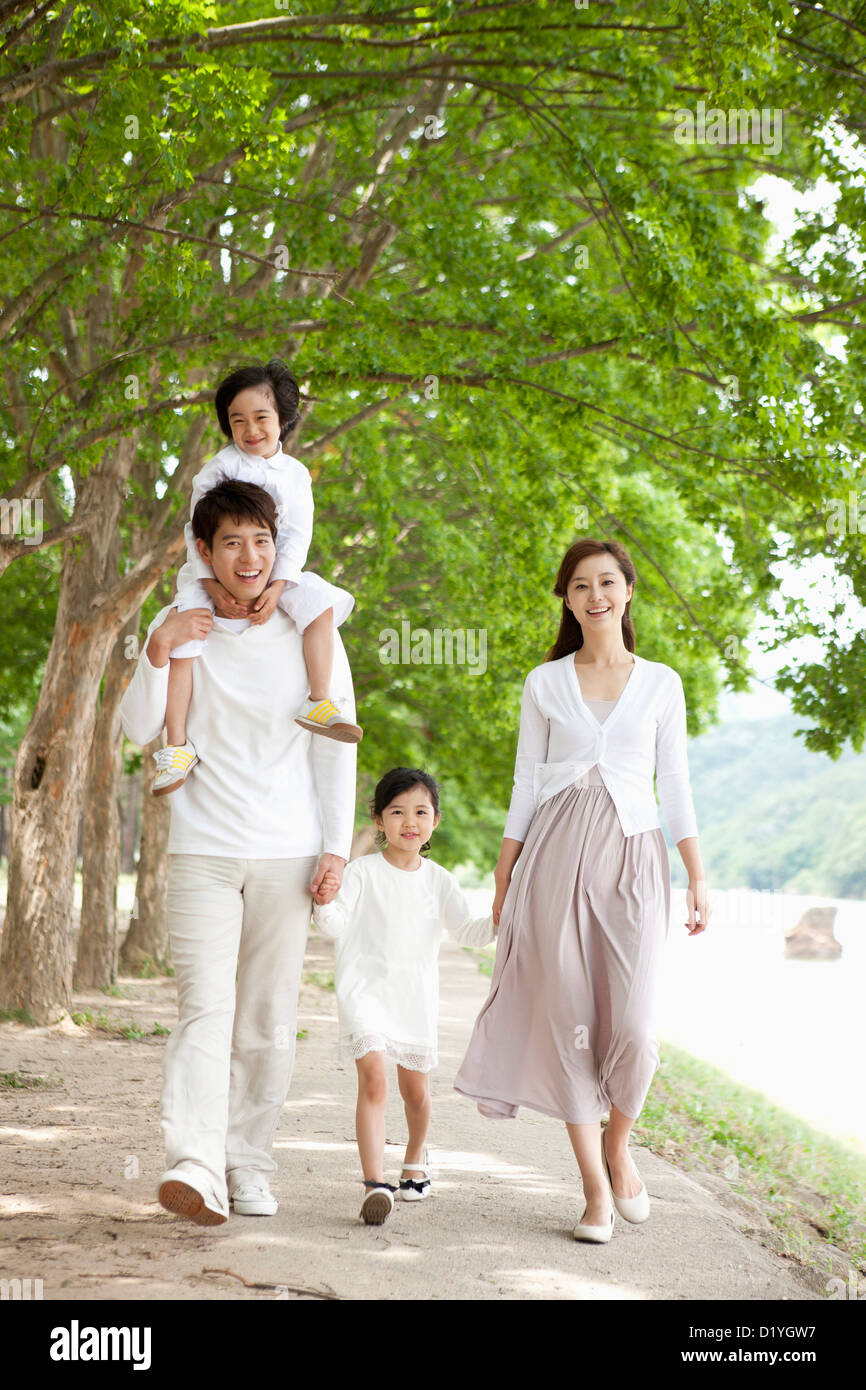 a family walking along a trail with trees Stock Photo - Alamy