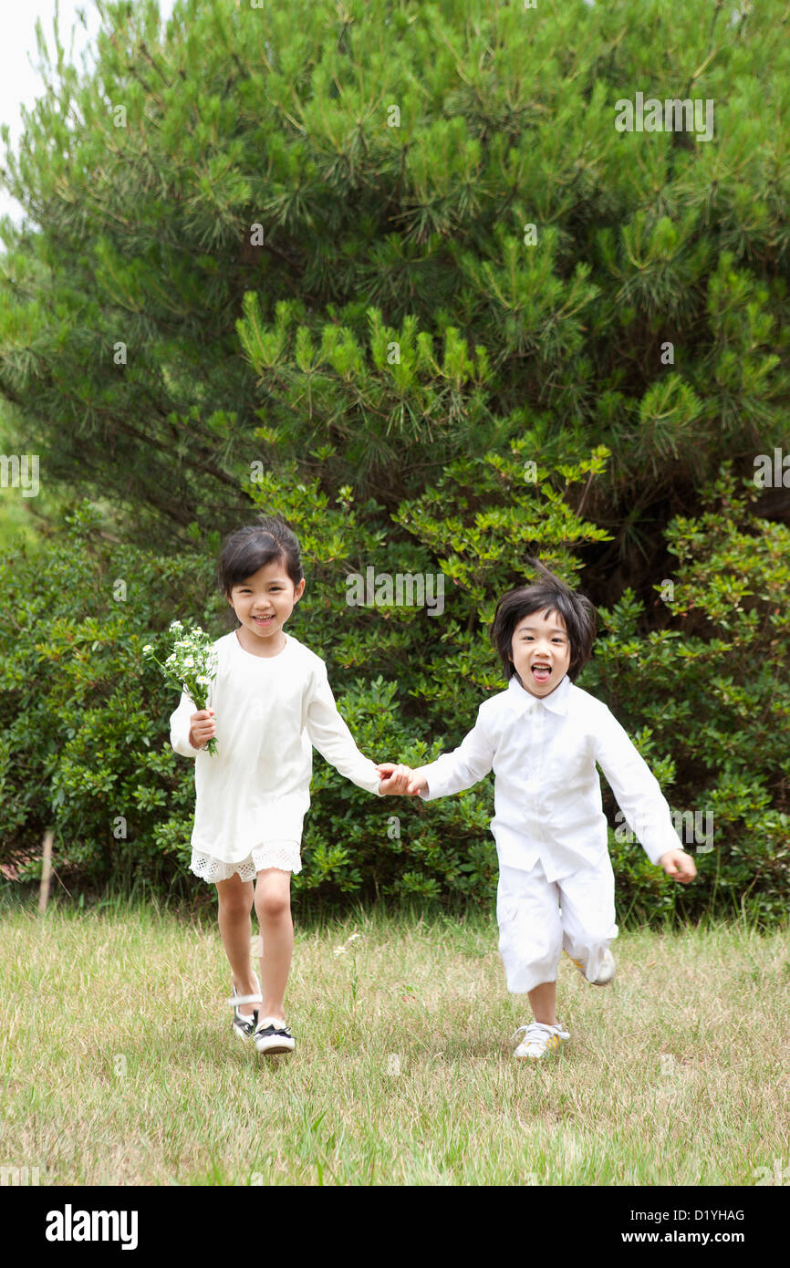 kids running on grass hand in hand Stock Photo - Alamy