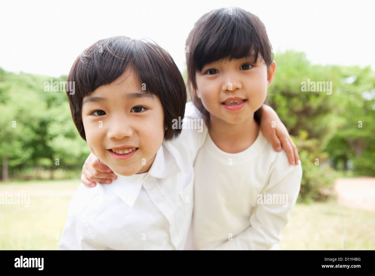 two kids posing with arms around each other Stock Photo - Alamy