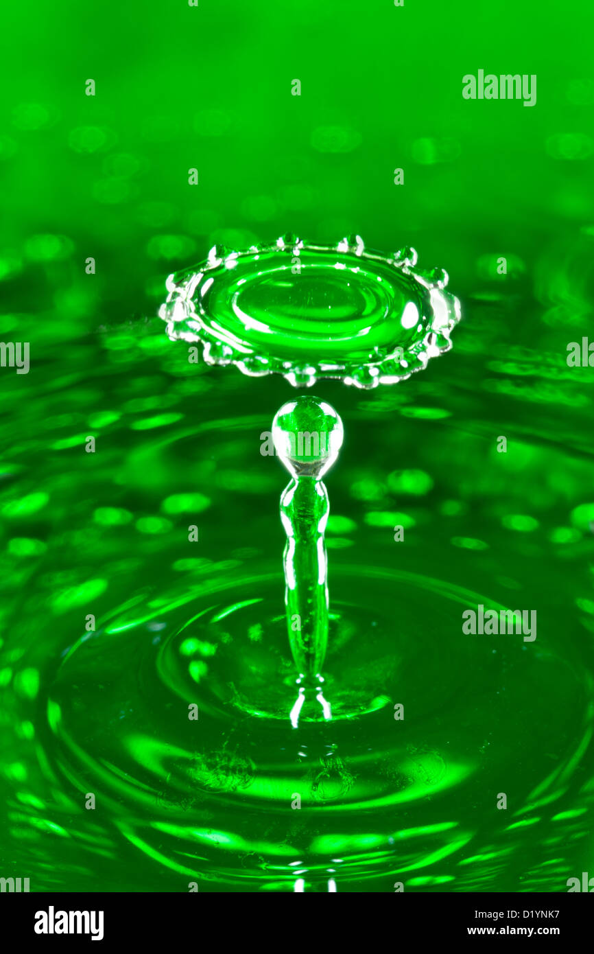 water drop falls downwards breaking about a drop Stock Photo - Alamy