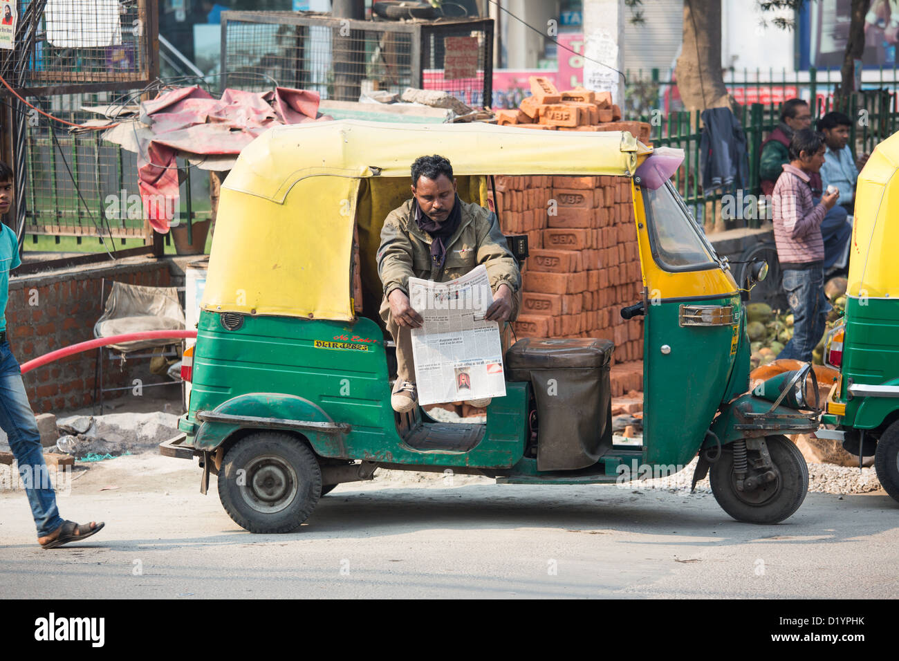 Rickshaw driver reading a newspaper in Delhi, India Stock Photo - Alamy