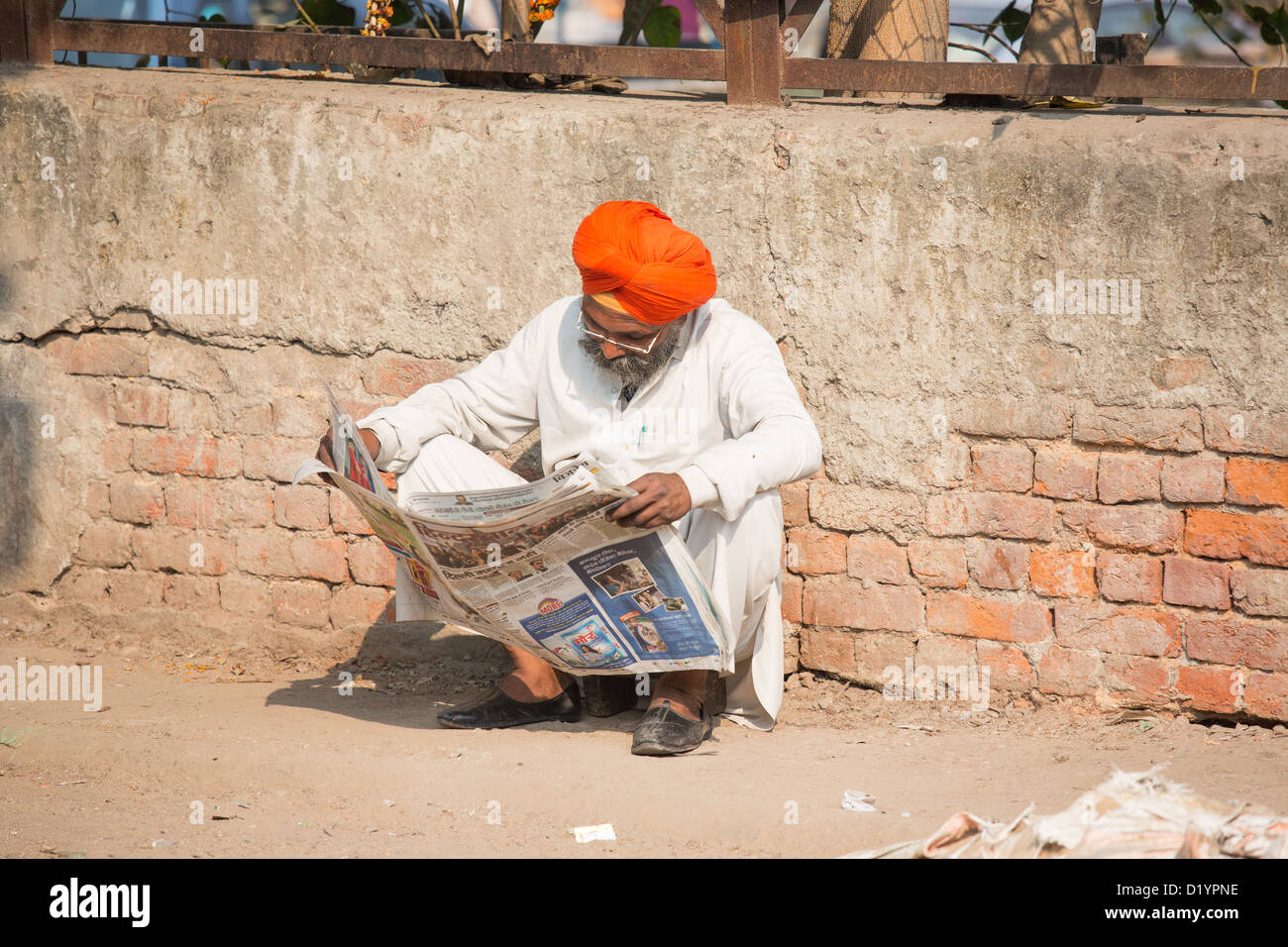 Indian man reading a newspaper in Delhi, India Stock Photo - Alamy