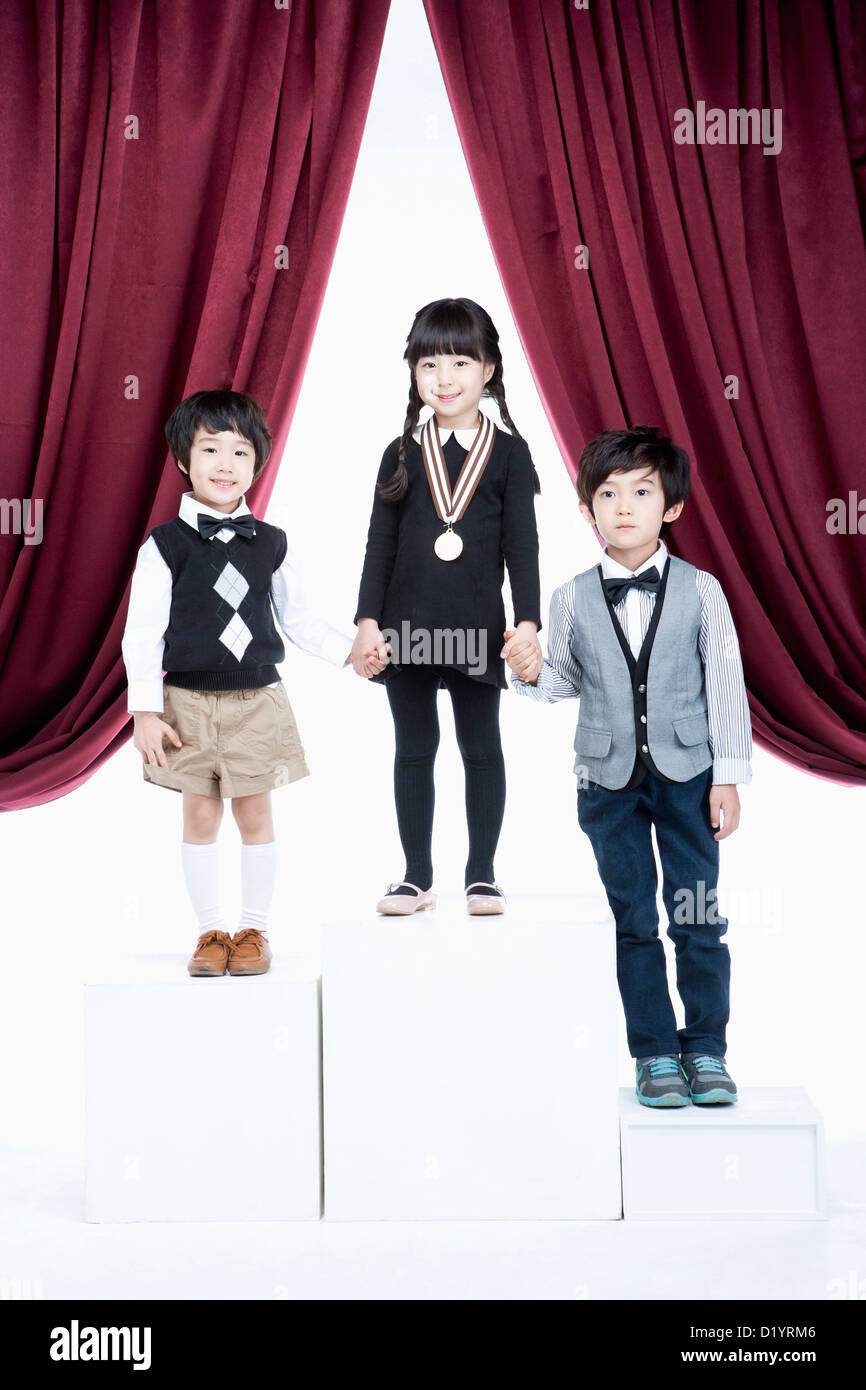 kids standing on podium in front of red curtains Stock Photo - Alamy