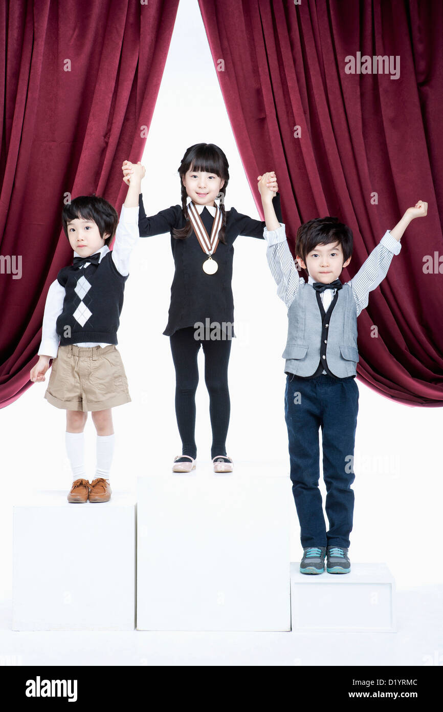 kids standing on podium raising their hands Stock Photo - Alamy
