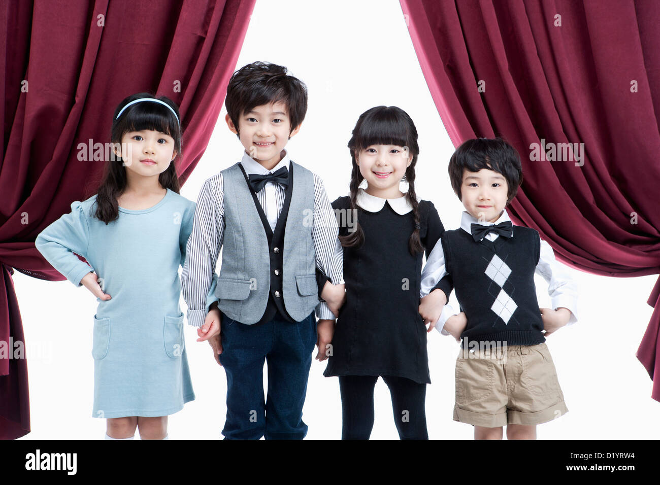 four kids on a stage with arms in arms Stock Photo - Alamy