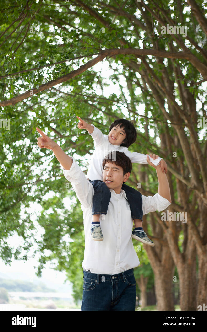 a son sitting on father's shoulders posing Stock Photo - Alamy